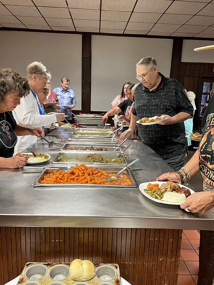 The buffet line moves with the precision of a well-choreographed dance, with bright orange carrots providing a beacon of vegetable virtue.
