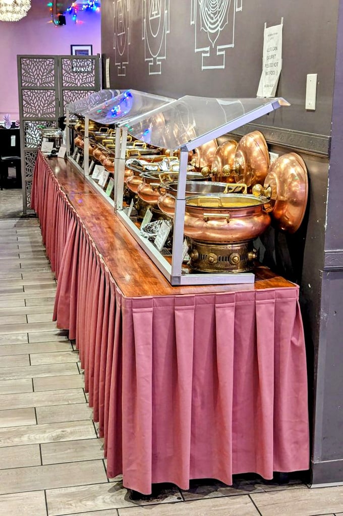 The buffet line stretches like a copper-clad runway of deliciousness, each vessel promising a different aromatic adventure.