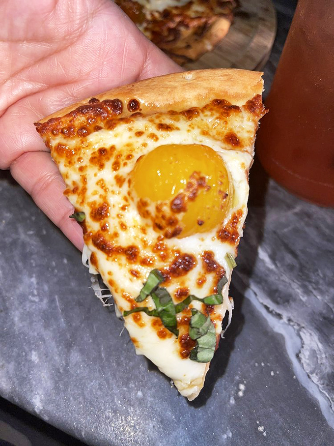 Pizza perfection: A crispy crust crowned with melted cheese, a sunny-side-up egg, and fresh basil&mdash;breakfast, lunch, and dinner solved in one slice.