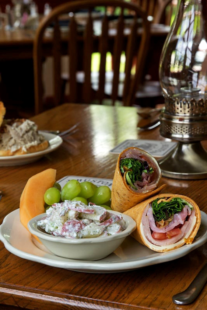 A masterful wrap with premium deli meats, fresh greens, and potato salad on the side&mdash;simple food executed with quiet confidence.