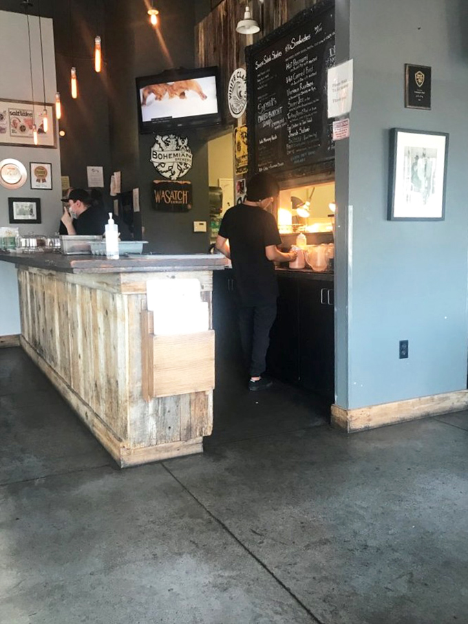 The rustic wooden counter where sandwich dreams come true. Behind it, culinary magicians transform simple ingredients into towering masterpieces.