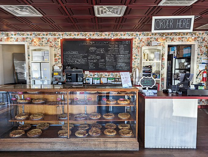 The display case stands like a museum of edible art, each pie a masterpiece waiting for its turn in the spotlight of your taste buds.