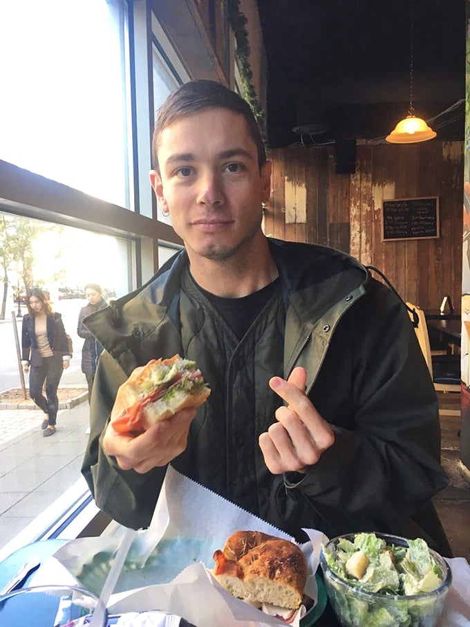 A customer enjoying that magical moment when sandwich meets mouth and all conversation stops for a brief moment of culinary bliss.