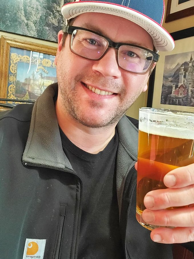 The image shows a patron enjoying a cold beer alongside their meal in the restaurant's comfortable dining area.