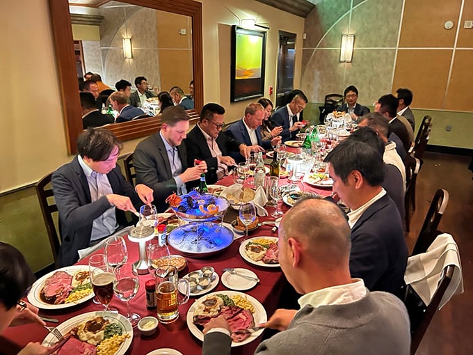 A gathering where prime rib is the unspoken language—notice how everyone's slightly hunched over their plates, universal body language for "don't even think about asking for a bite."