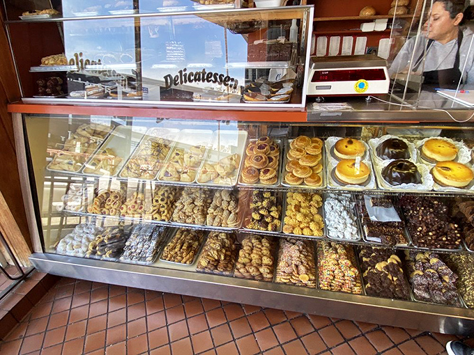 A display case that should come with a warning label: "May cause spontaneous drooling." Each pastry sits like a jewel in the world's most delicious treasure chest.