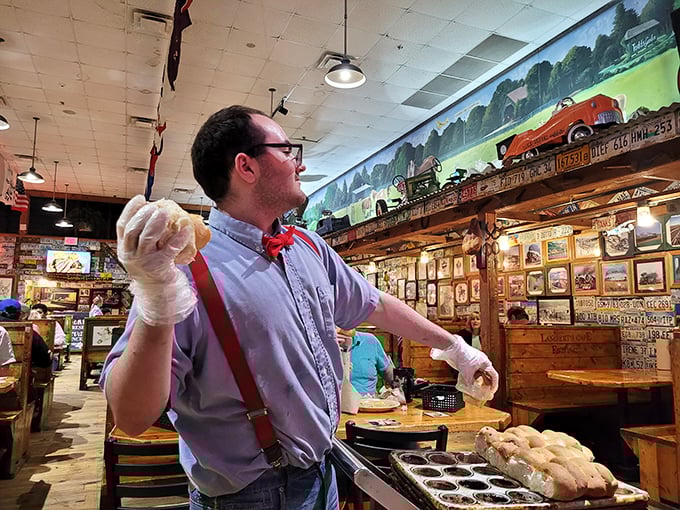 The roll thrower prepares for liftoff! With practiced precision and showman's flair, he'll soon have diners catching carbs with big smiles.