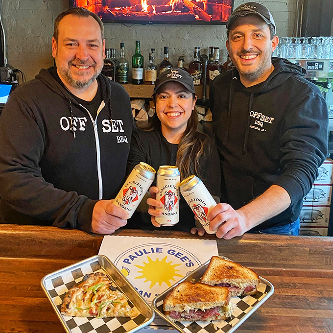 The passionate team behind Offset BBQ, holding craft beers and sandwiches with the pride of new parents.