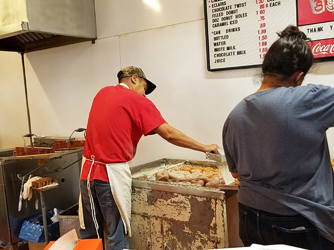 The magicians at work, transforming simple ingredients into transcendent treats. That fryer has probably seen more miracles than most religious institutions.