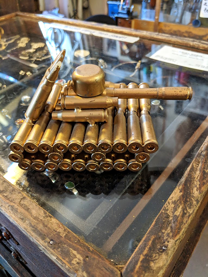 War becomes art in this bullet-crafted tank, transforming instruments of destruction into a miniature masterpiece behind protective glass.