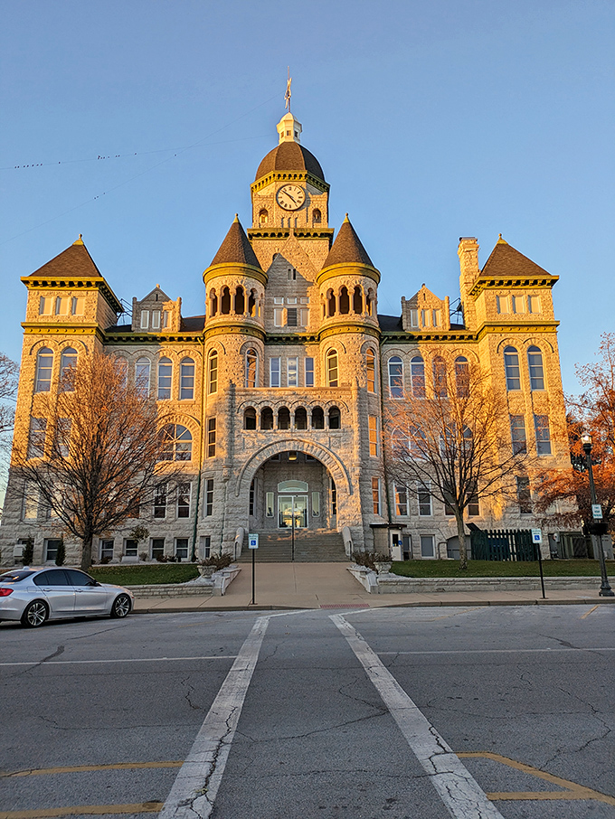 The Jasper County Courthouse glows golden in late afternoon light, its Romanesque Revival architecture more castle than government building.