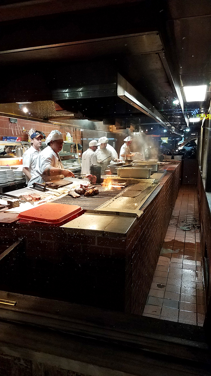 The open kitchen isn't theater&mdash;it's transparency. Chefs in white working the grill with practiced precision, creating the smoky magic that keeps people coming back decade after decade.