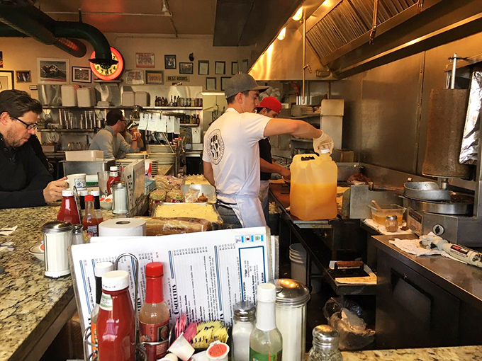 The kitchen ballet—where spatulas fly and orders materialize into the comfort food that's sustained Denver through booms, busts, and everything between.