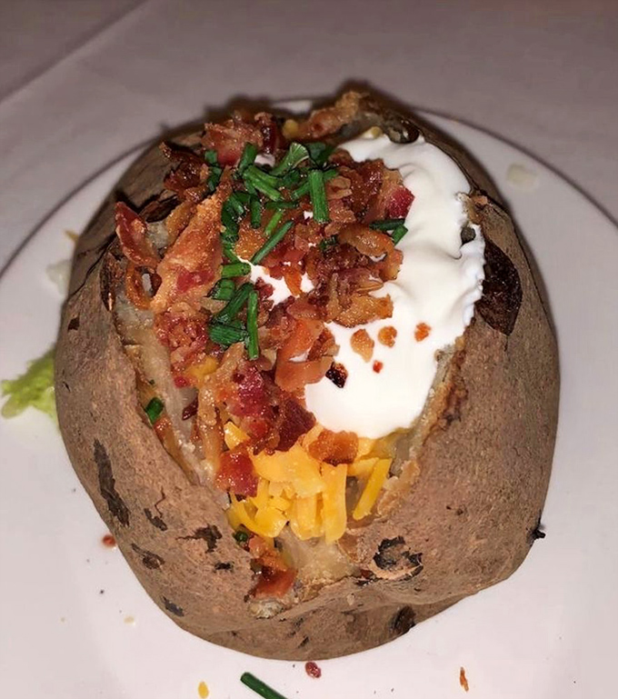 The loaded baked potato comes dressed for a night on the town, adorned with bacon, cheese, chives, and enough sour cream to make a cardiologist nervous.