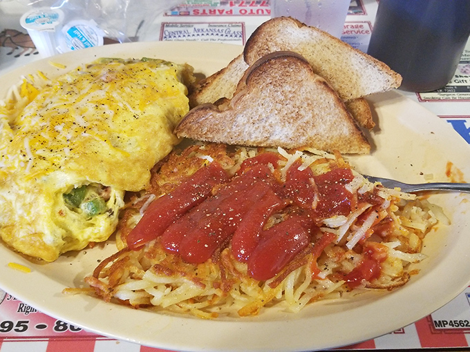 This plate tells the eternal breakfast story: eggs, hashbrowns with ketchup, and toast&mdash;simple ingredients elevated to morning masterpiece status.