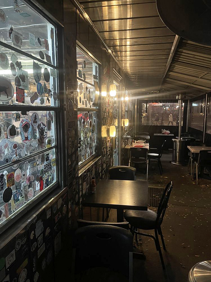 Even at night, the diner's interior glows with promise, sticker-covered walls creating a museum of midnight memories.