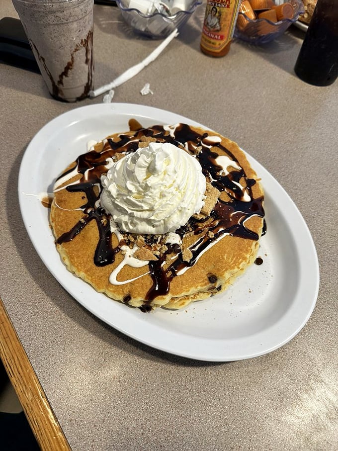 Pancake architecture at its finest&mdash;structural integrity supporting that cloud of whipped cream and chocolate drizzle. Breakfast or dessert? Yes.