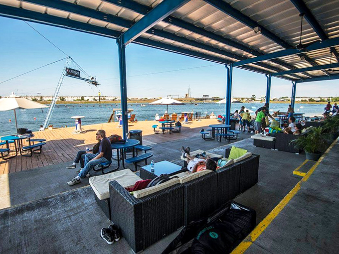 The covered lounge area provides front-row seats to wakeboarding action—part living room, part sports arena, all relaxation.