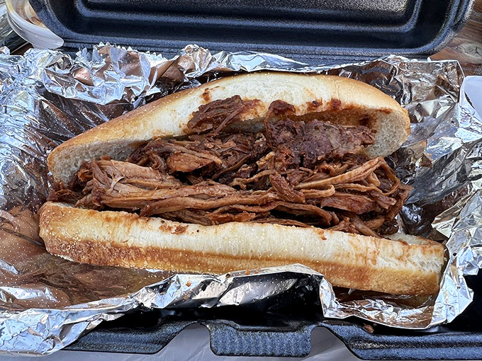 A pulled pork sandwich so generously stuffed it makes you wonder if they misunderstood the concept of "sandwich" to mean "meat mountain."