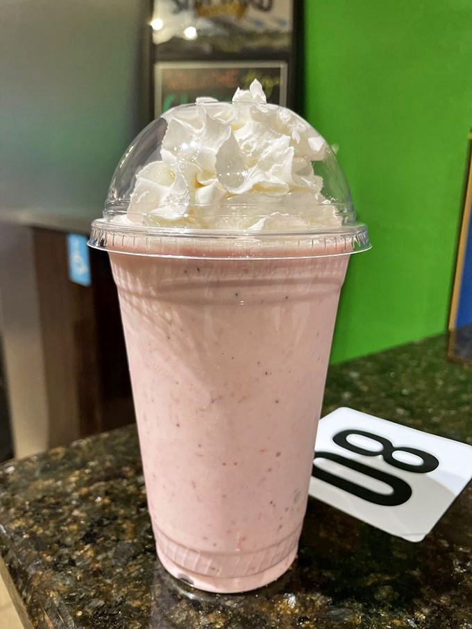 The strawberry milkshake arrives crowned with whipped cream, like dessert royalty that knows exactly how fabulous it is.