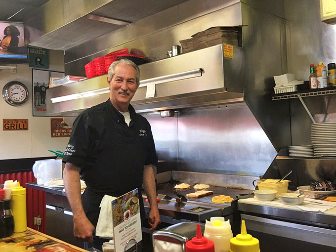 Behind every great diner is someone who understands that food is love. The grill master's smile says you're in for something special.