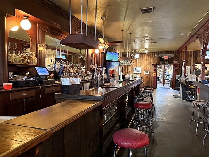 The bar area whispers of Prohibition-era secrets while serving perfectly legal libations. Those red bar stools have heard some stories.
