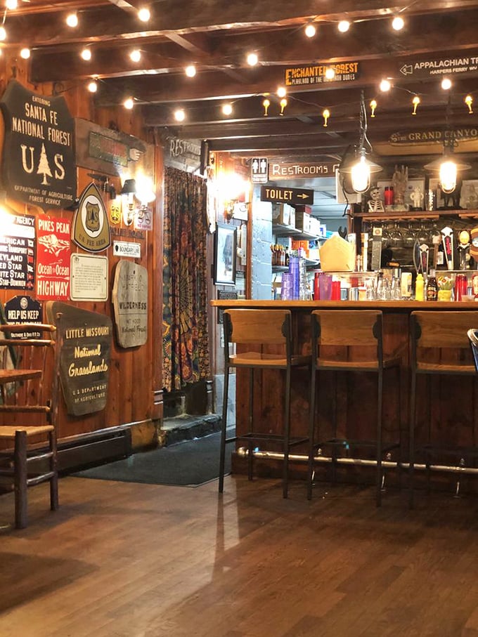 The bar area whispers "stay awhile" with its warm wood tones and vintage signs. Even the restroom directions have personality here.