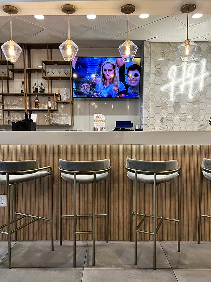 The bar setup whispers "craft cocktails" without shouting "pretentious mixology." Those pendant lights could make anyone look ready for their close-up.