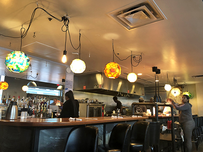 The bar area glows with colorful pendant lights that look like illuminated Easter eggs, creating a morning vibe that's equal parts energizing and soothing.