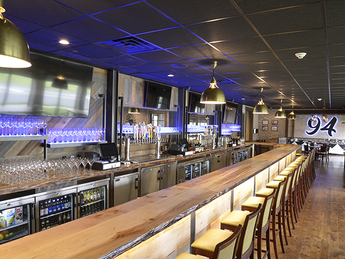 The bar stretches out like a runway for drinks, with blue lighting that makes every glass of bourbon look like it's ready for its close-up.