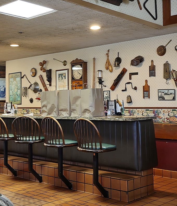 Vintage kitchen tools adorn walls above counter seats&mdash;silent witnesses to decades of "I shouldn't have room for dessert, but..."