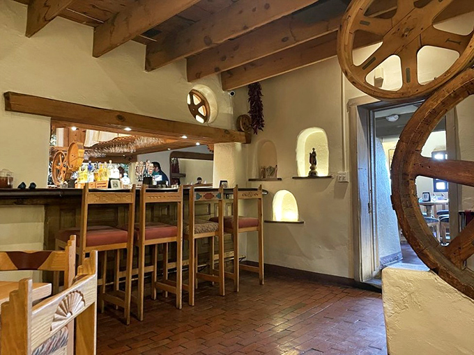 The bar area combines rustic charm with Old West flair—those wagon wheels aren't just decoration; they're time machines to New Mexico's frontier days.