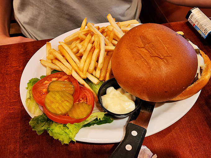 The classic American burger&mdash;architectural perfection between two buns. Notice how the knife stands at attention, ready for the first bite.