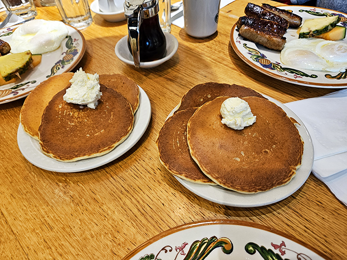 These aren't just pancakes; they're golden discs of happiness topped with butter clouds that melt into warm maple rivers.