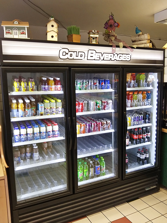 The beverage cooler stands ready with liquid companions for your pastry adventure—because even the perfect donut occasionally needs a wingman.