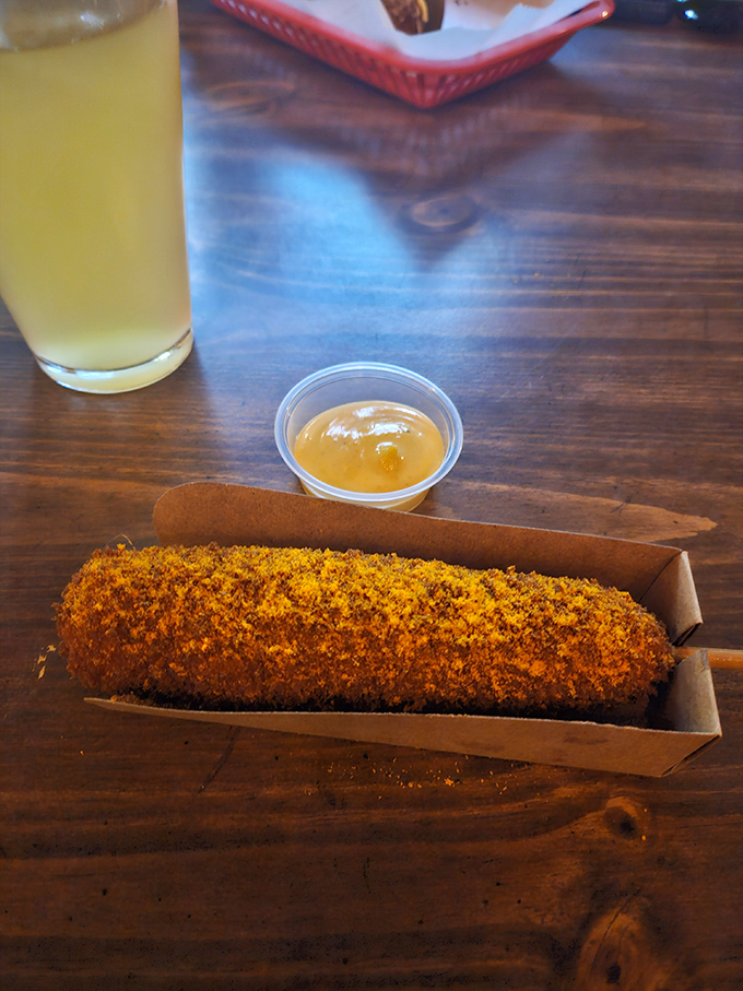 A golden-brown corndog that would make any state fair jealous, paired with a dipping sauce worth abandoning your game for.