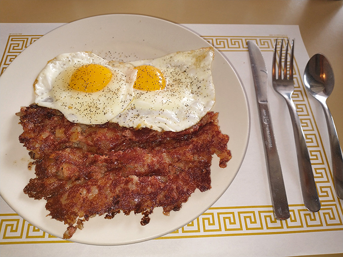 Breakfast perfection that doesn't need filters &ndash; sunny-side up eggs keeping watch over a crispy landscape of corned beef hash. 