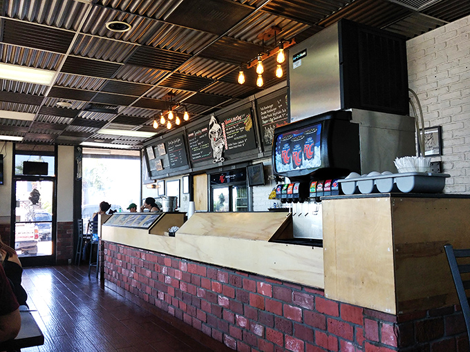 Behind this counter, sandwich artisans work their magic – the brick facade and industrial ceiling lights setting the stage for culinary theater.
