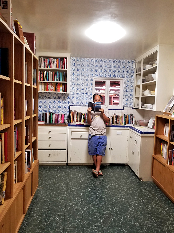 Blue Dutch tiles transform this cozy kitchen-turned-reading-room into a European literary escape where every corner invites lingering.