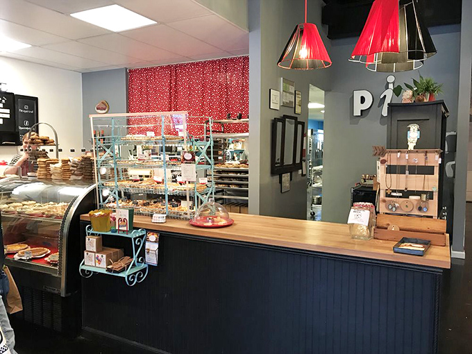 The counter where pie dreams come true. That turquoise shelving isn't just holding pastries—it's displaying edible works of art waiting for their forever homes.