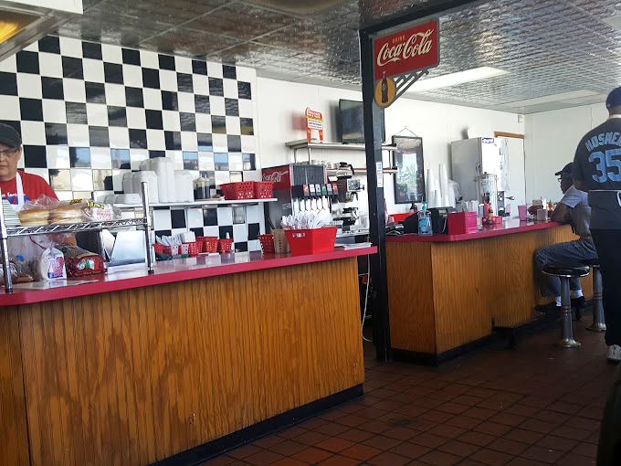 The counter where regulars perch like birds on a wire, exchanging news and opinions over endless coffee refills.