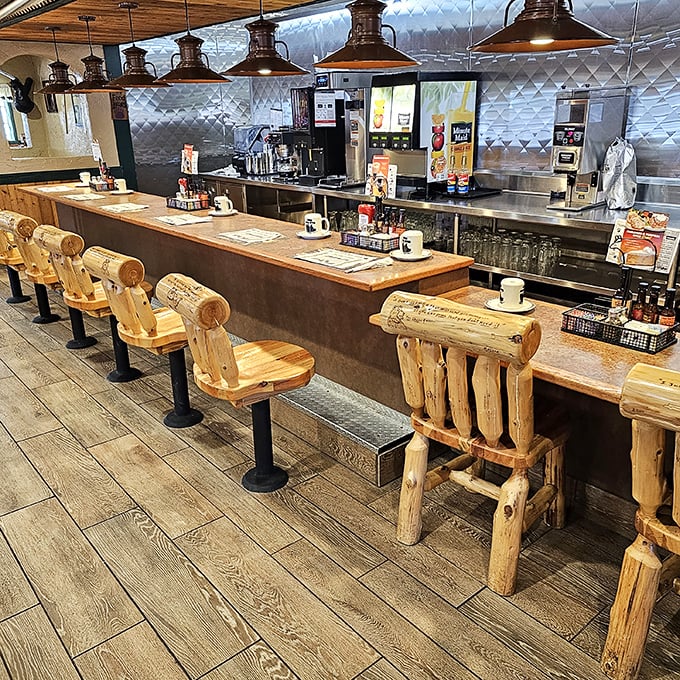 Log cabin chic meets diner practicality at the counter. Those wooden stools aren't just seating&mdash;they're front-row tickets to the breakfast show.