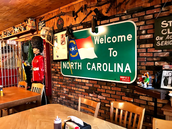 A "Welcome to North Carolina" sign among countless mementos &ndash; because this place isn't just serving food, it's offering a taste of local identity.