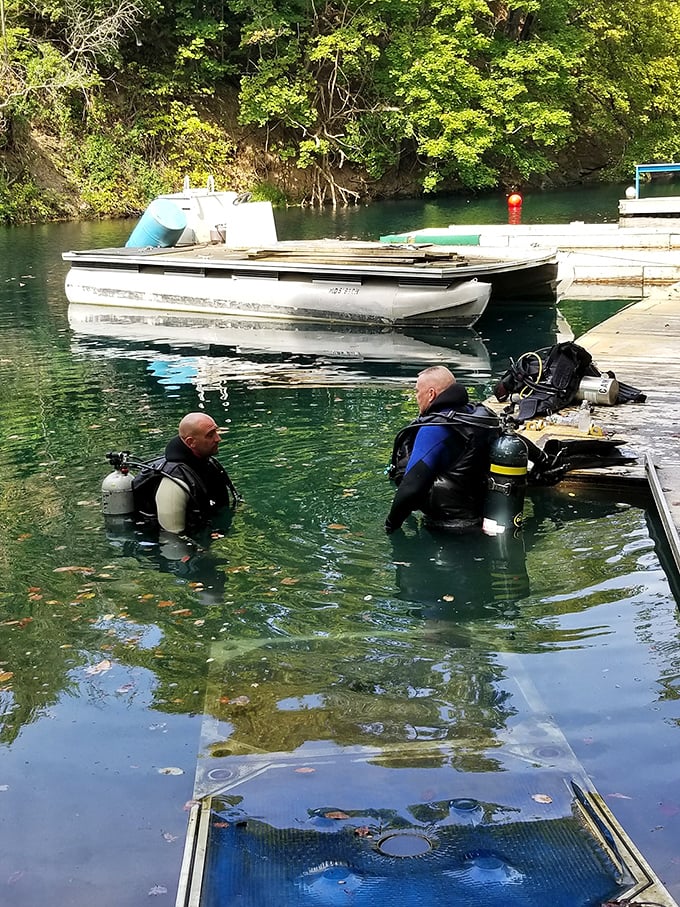 Underwater explorers prepare to discover the quarry's depths. These scuba enthusiasts remind us there's a whole other world beneath the splashing surface.