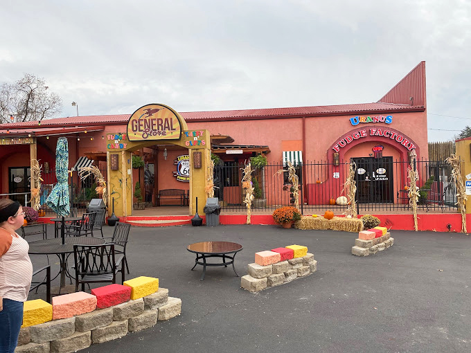 The salmon-colored exterior of the General Store welcomes visitors with its distinctive southwestern flair. Outdoor seating invites travelers to rest while enjoying their freshly packed fudge.