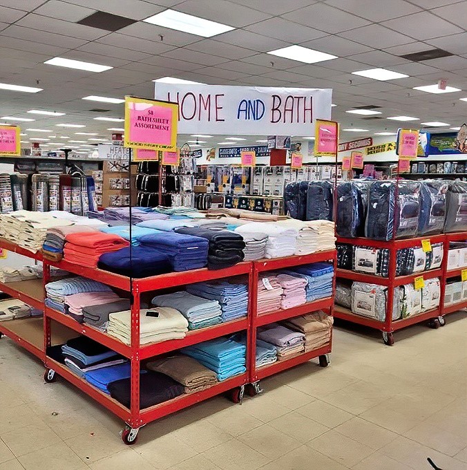 The Home and Bath section offers towels stacked with military precision, creating a textile rainbow that would make Martha Stewart nod in budget-conscious approval.