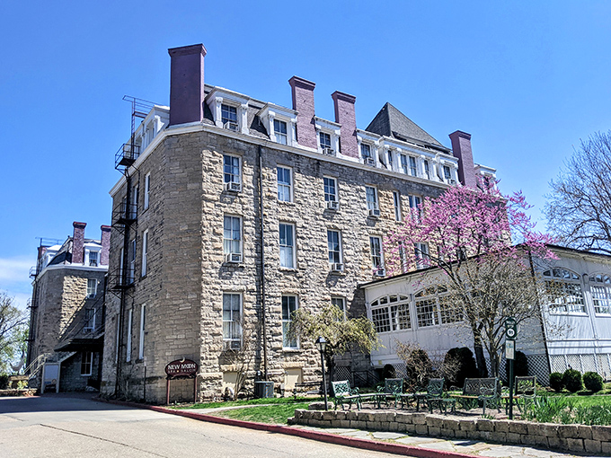 The Crescent Hotel stands majestically against blue skies, its limestone walls housing equal parts luxury and ghostly legends.