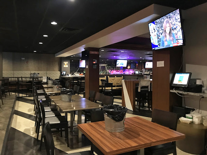 The dining room balances casual and intentional&mdash;where TVs broadcast games while tables host serious discussions about whether to order more hushpuppies.