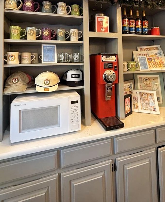 The merch wall says, "Yes, you can take a piece of Tato-Nut home." Coffee mugs and hats: souvenirs for the truly devoted donut disciples.