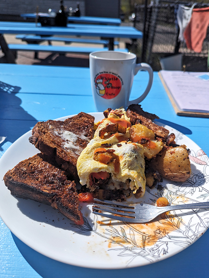 Blue tables that match the Connecticut sky, creating the perfect backdrop for this carefully constructed breakfast masterpiece. The fork stands ready for the first magnificent bite.
